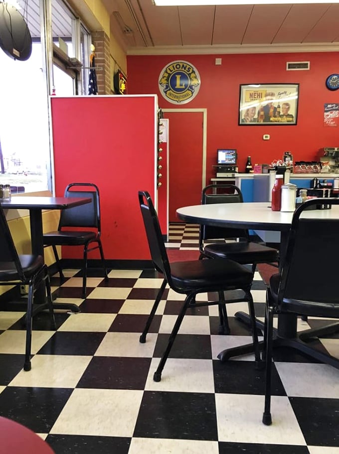 Red walls, checkered floors, and those classic diner chairs—this isn't just decoration, it's a time machine to when comfort food reigned supreme.