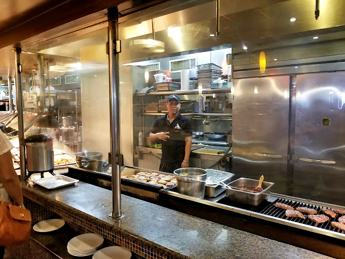 Behind glass walls, culinary magic happens in real-time. The open kitchen concept lets you witness your seafood journey from preparation to plate.