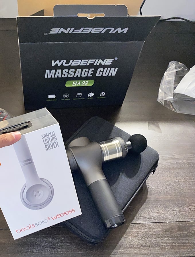Massage guns and Beats headphones sharing bin space—like finding a spa day and concert tickets in the same lucky dip.