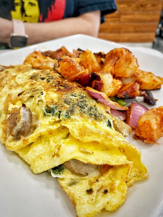 This isn't just an omelet—it's a masterclass in egg architecture, stuffed with veggies and paired with potatoes that have achieved crispy-tender nirvana.