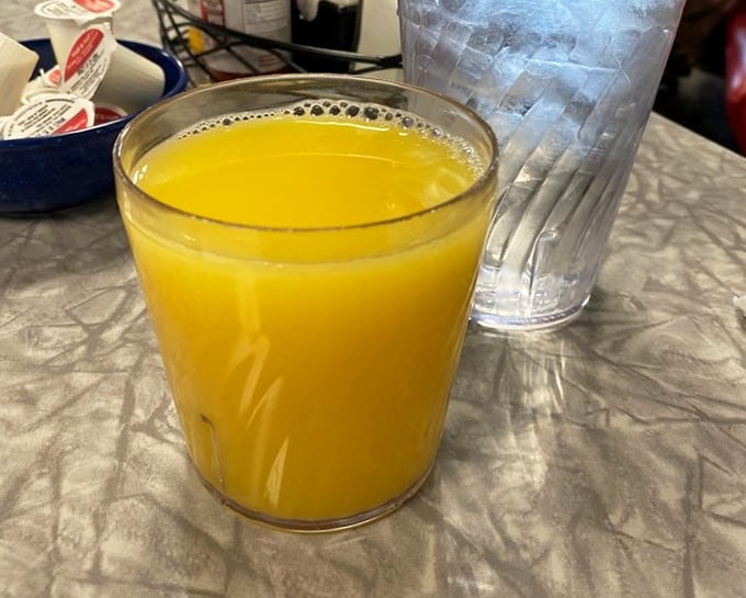 That orange juice isn't just a beverage—it's liquid sunshine in a glass, the perfect companion to whatever breakfast masterpiece you've ordered.