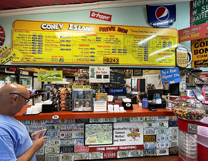 The order counter isn't just where food magic happens—it's a shrine to American road trips, decorated with license plates from dreams and journeys past. 
