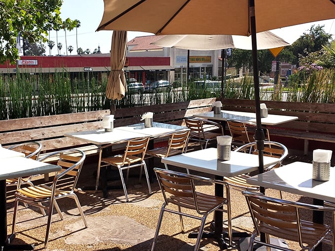 The outdoor patio—where palm trees stand guard over conversations, and the California sun blesses every bite with vitamin D and good vibes.