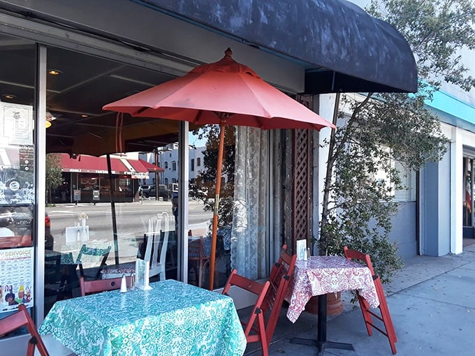 Sidewalk dining under red umbrellas – because great pizza tastes even better with a side of California sunshine.