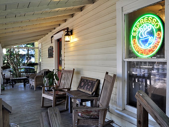 The neon espresso sign glows like a lighthouse for the caffeine-deprived. Those weathered chairs have heard more good conversations than most therapists.