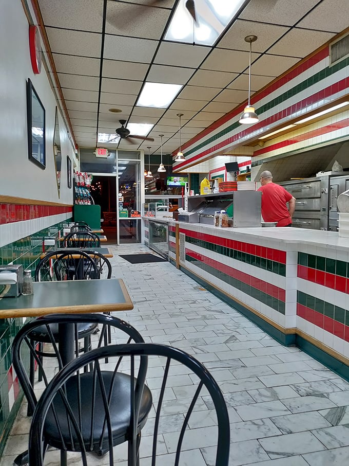 The narrow dining area offers front-row seats to the pizza-making action, with those iconic Italian flag colors setting the mood.