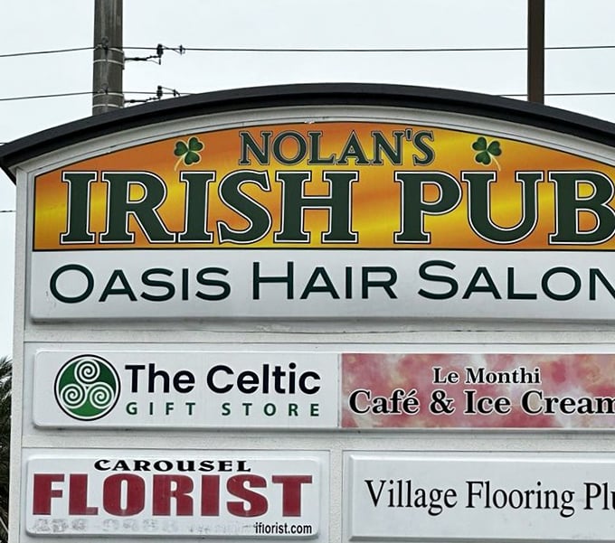 The neighborhood sign reveals Nolan's Irish Pub shares space with unlikely neighbors—proof that in Florida, hair salons and Celtic gifts coexist in perfect harmony.