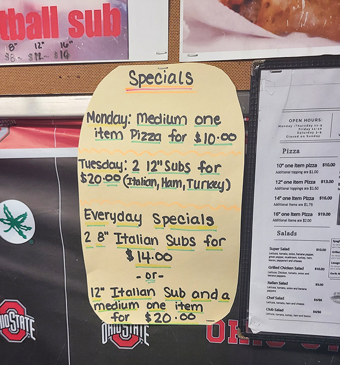 Hand-written specials board—where budget-friendly meets mouth-watering. Tuesday's two-sub deal might be the best thing since sliced bread.