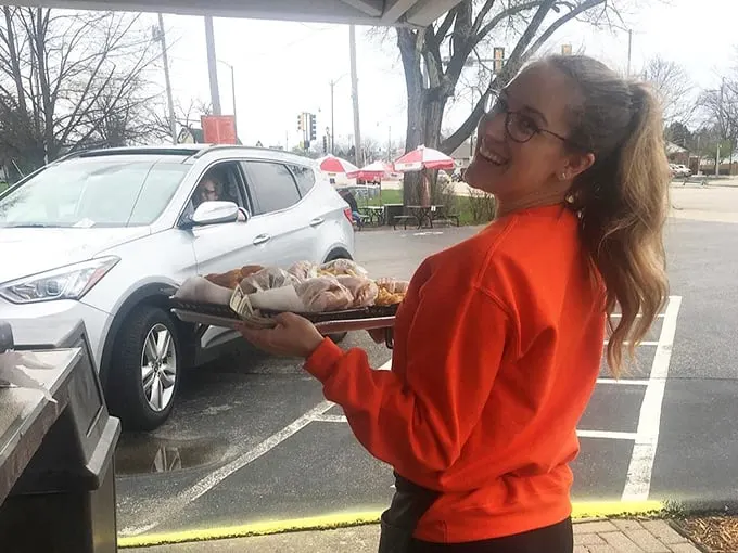 Carrying trays of goodness with a smile—Ace Drive-In's food tastes even better when served with genuine Midwestern hospitality.