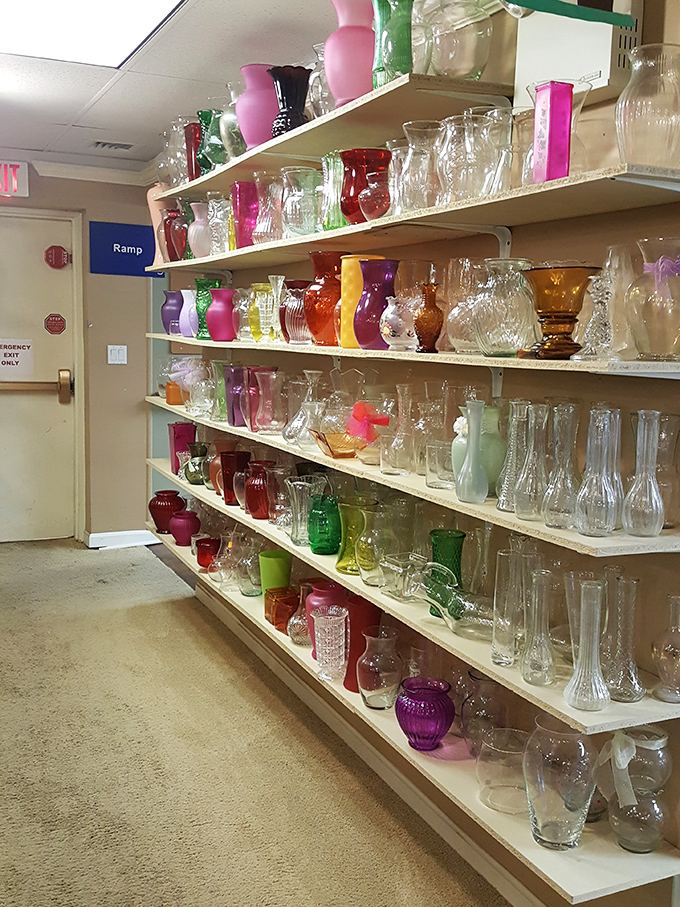 The glassware aisle glows with color—vases and vessels from every decade standing at attention like a rainbow regiment of potential flower holders.