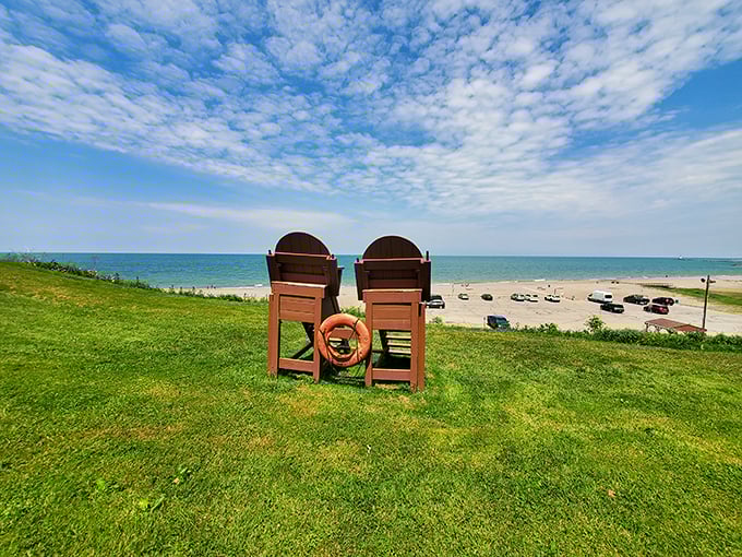 Two Adirondack chairs perched on the grassy overlook—nature's perfect theater seats for watching the lake's ever-changing performance.