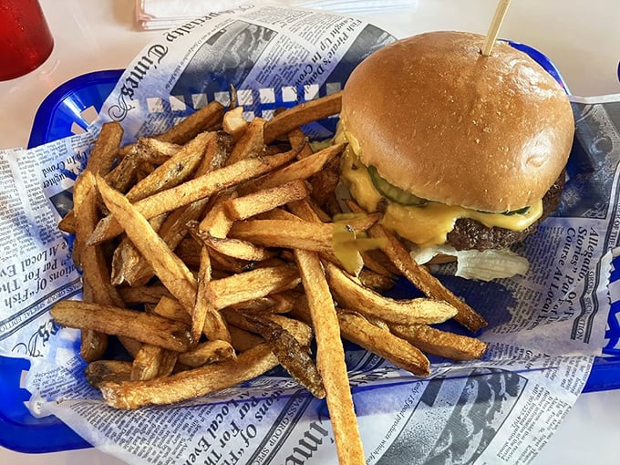 A burger and fries served on newspaper – because sometimes the classics don't need reinvention, just reverence and proper execution.