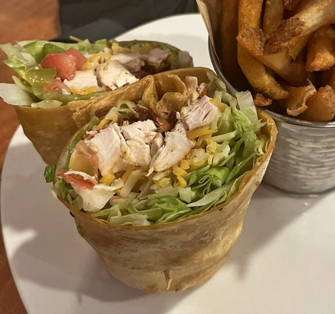This wrap isn't just stuffed—it's generously sharing its abundance with the plate. Fresh ingredients playing nicely together in their tortilla home.