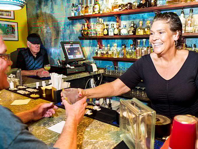 This bartender's smile suggests she knows exactly how good those margaritas are about to make your day.