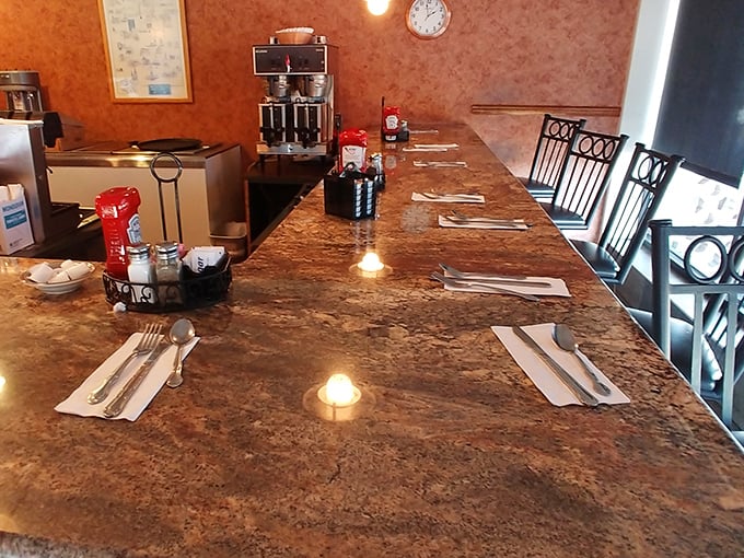 The counter seating—where solo diners become regulars, coffee flows freely, and the best local gossip is exchanged over perfectly set place settings.