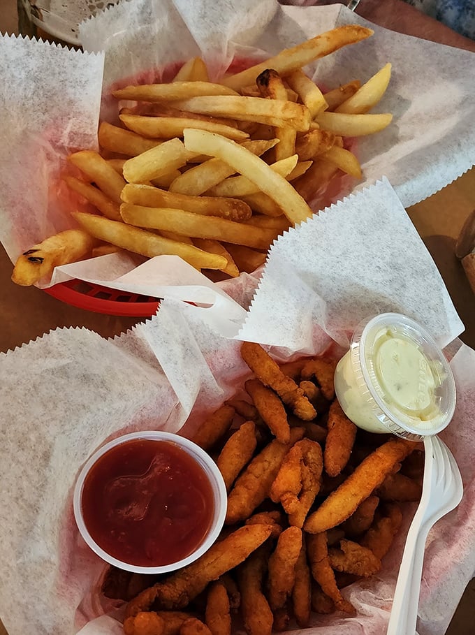 Golden fries and crispy seafood bites served in paper baskets—the universal language of coastal comfort food done right.