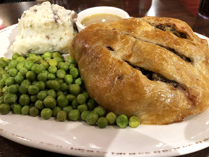 Not all heroes wear capes—some come wrapped in golden pastry alongside creamy mashed potatoes and vibrant peas. Comfort food, elevated.