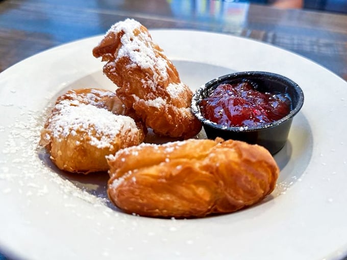 Pillowy beignets dusted with powdered sugar's gentle snow—New Orleans tradition meets Maryland hospitality on a perfectly simple white plate.