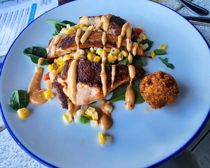 Blackened salmon that proves sometimes the best flavor combinations are the simplest—fish, corn, greens, and a sauce worth licking off the plate.