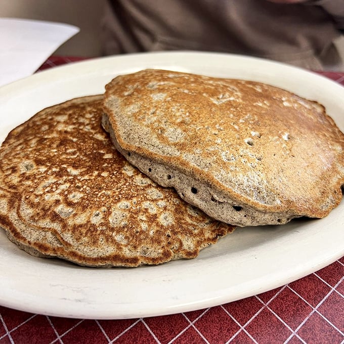 Buckwheat pancakes with the perfect golden-brown complexion—like edible frisbees of joy that make maple syrup feel like it's found its soulmate.