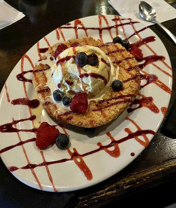 Dessert that demands a moment of silence – warm butter cake crowned with ice cream and berries in a presentation that's both elegant and playful.