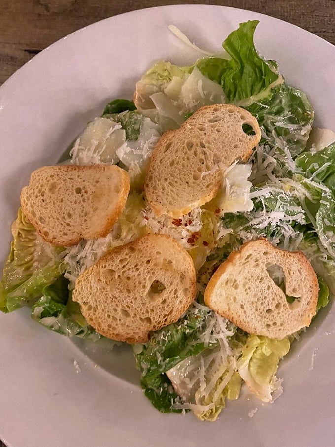 A Caesar salad that respects tradition—crisp romaine, shaved cheese, and croutons that crackle like autumn leaves. Simple pleasures done right.