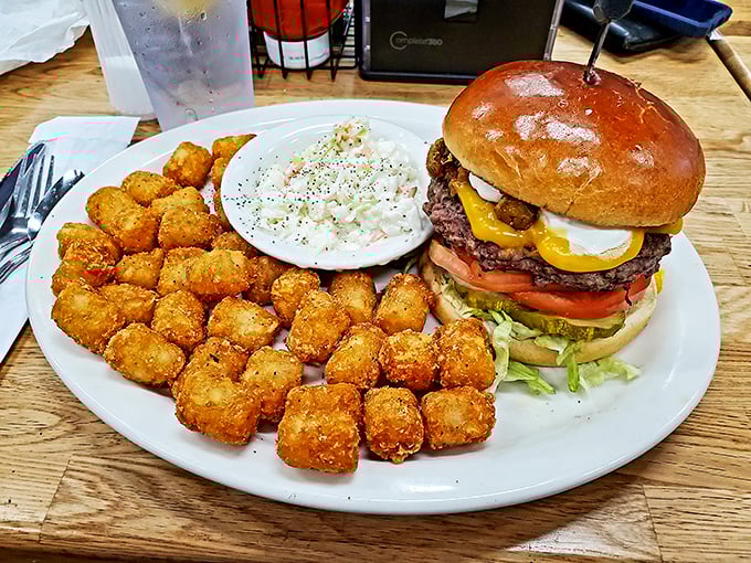 This isn't just a burger—it's an engineering marvel. Those golden tots stand at attention, ready for their supporting role in your happiness.