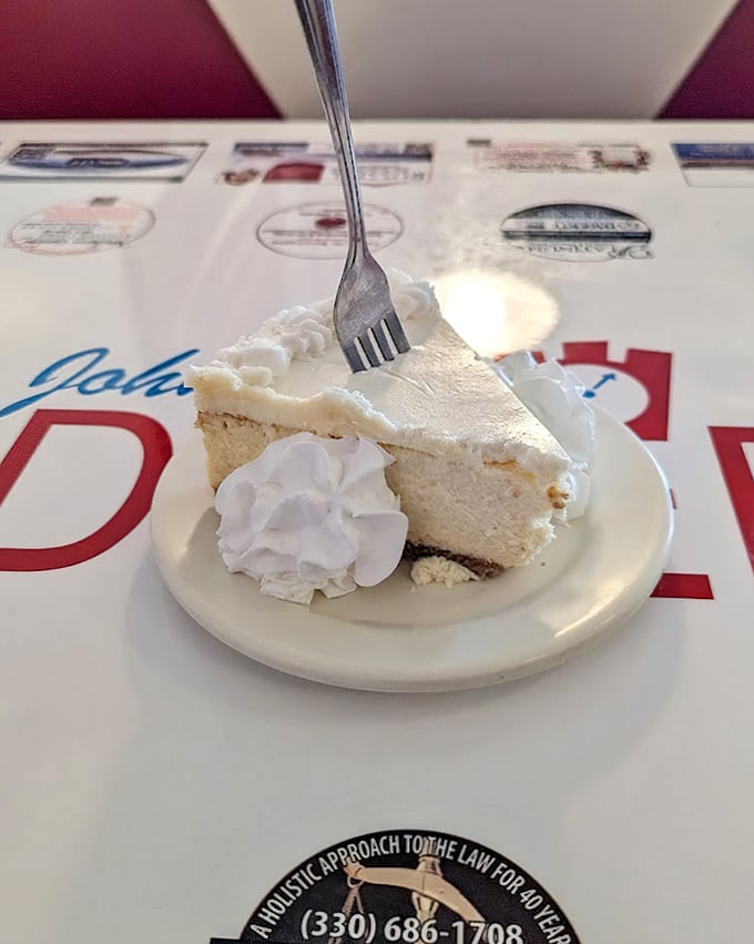 Cheesecake so light it practically hovers above the plate. That dollop of whipped cream isn't decoration – it's the exclamation point on a perfect dessert sentence.