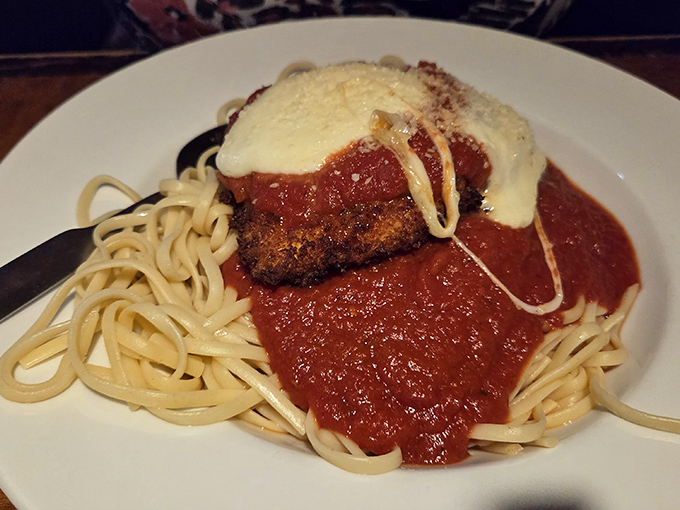 Chicken Parmesan that doesn't mess around—crispy cutlet, tangy marinara, and melted cheese atop a bed of pasta that knows its supporting role.