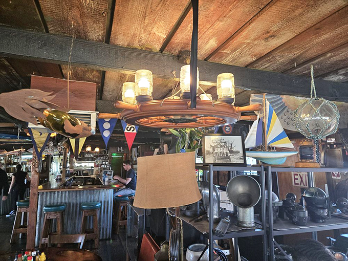 Overhead inspiration for seafaring appetites. The ship's wheel chandelier and nautical flags aren't decoration—they're the Chowder Barge's family photos.