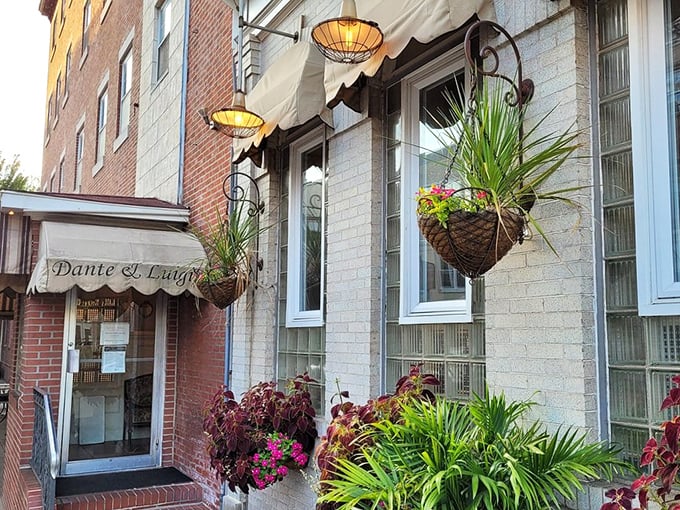 Hanging baskets and lush greenery frame the entrance, creating a secret garden vibe that whispers, "Psst, amazing pasta inside."