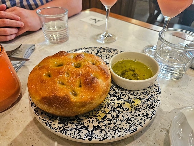 Focaccia that would make an Italian grandmother weep with joy. That glistening pool of olive oil isn't just a condiment—it's liquid gold for bread-dipping bliss.