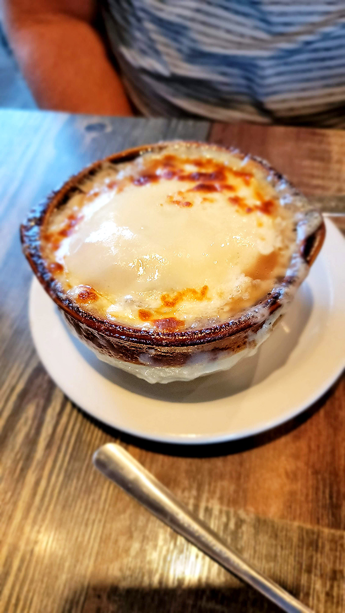 French onion soup with a golden crown of bubbling cheese—comfort food that somehow feels right at home alongside fresh seafood. 