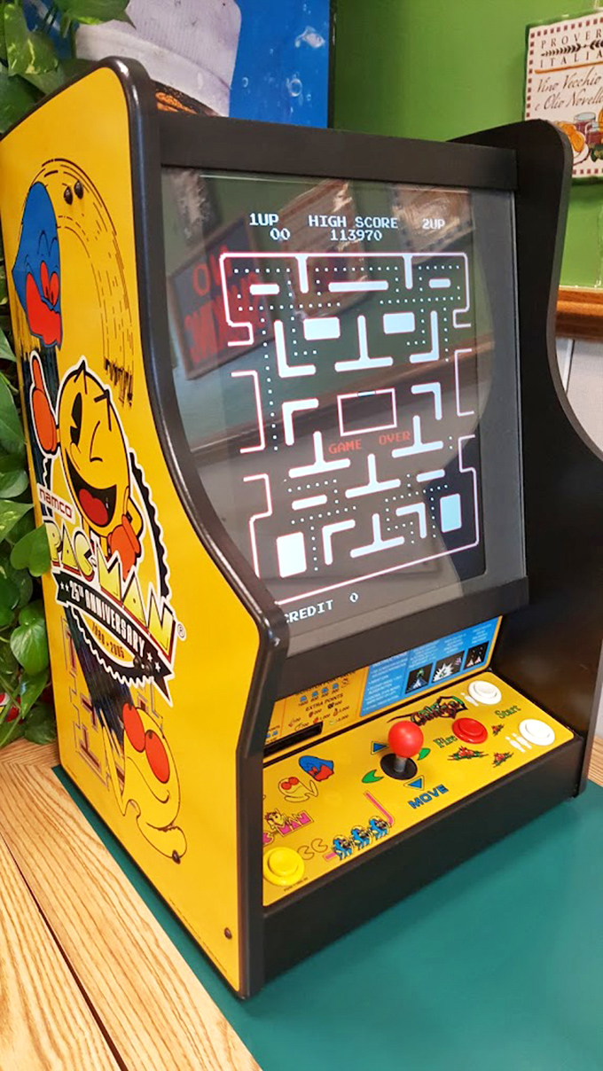 A vintage Pac-Man cabinet in the corner – because nothing complements a slice like the sweet symphony of 8-bit nostalgia.