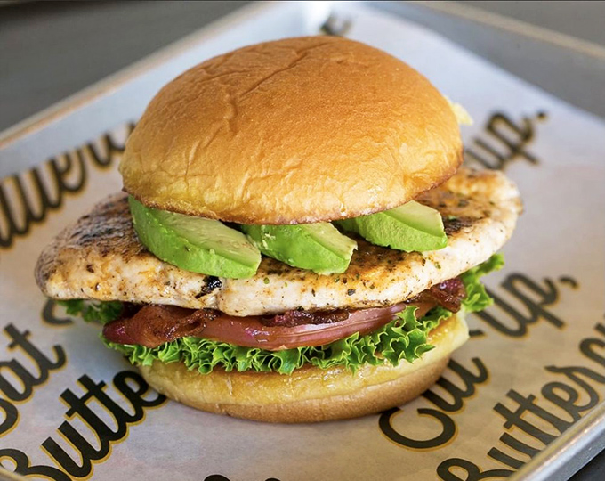 The Grilled Bacavo Sandwich proves healthy choices needn't be punishment—avocado and grilled chicken creating a guilt-free love affair on a bun.