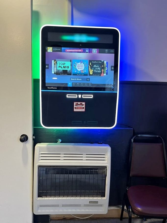 The modern jukebox stands as a technological oasis in this temple of tradition, offering musical accompaniment to your culinary journey through Americana.