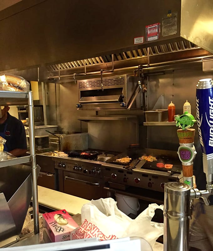 A glimpse into the kitchen reveals the sizzling heart of the operation, where sandwich components transform into edible art. 
