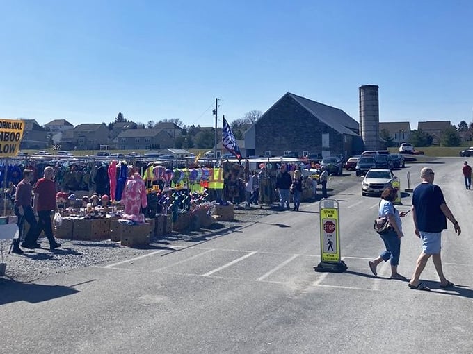 The market sprawls across the property like a small village, with shoppers navigating between outdoor stalls under the watchful eye of blue Pennsylvania skies.