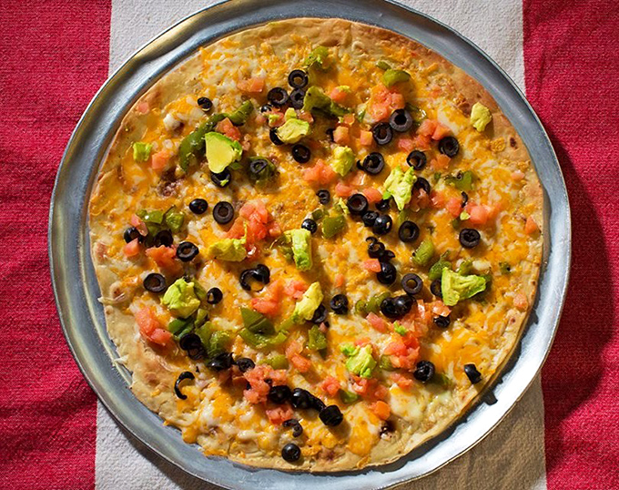 This Mexican pizza laughs at chain restaurant versions. Those fresh avocados aren't just toppings—they're a statement.
