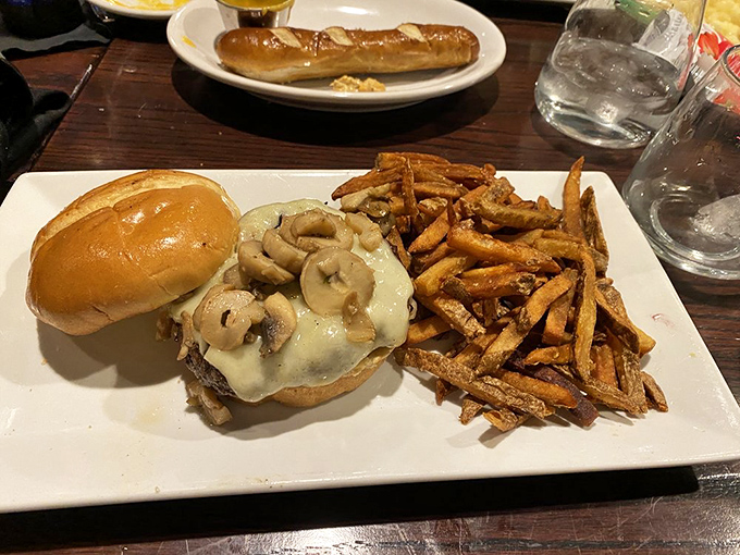 A burger that requires both hands, several napkins, and possibly a nap afterward. Those mushrooms aren't just toppings—they're a commitment to excellence.