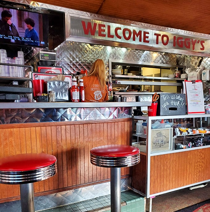 The counter where dreams come true, one order at a time. That Route 66 shirt isn't just merch—it's a uniform of American culinary heritage.
