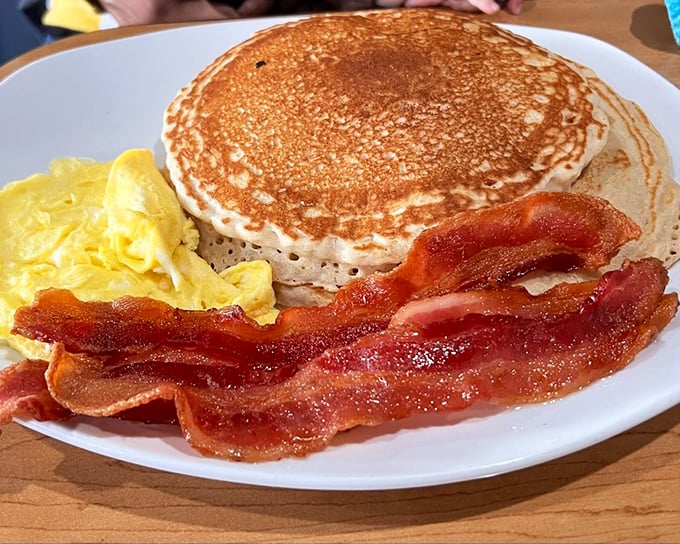 Golden pancakes with perfectly crisped bacon—the breakfast equivalent of a warm hug from your favorite aunt who really knows how to cook.