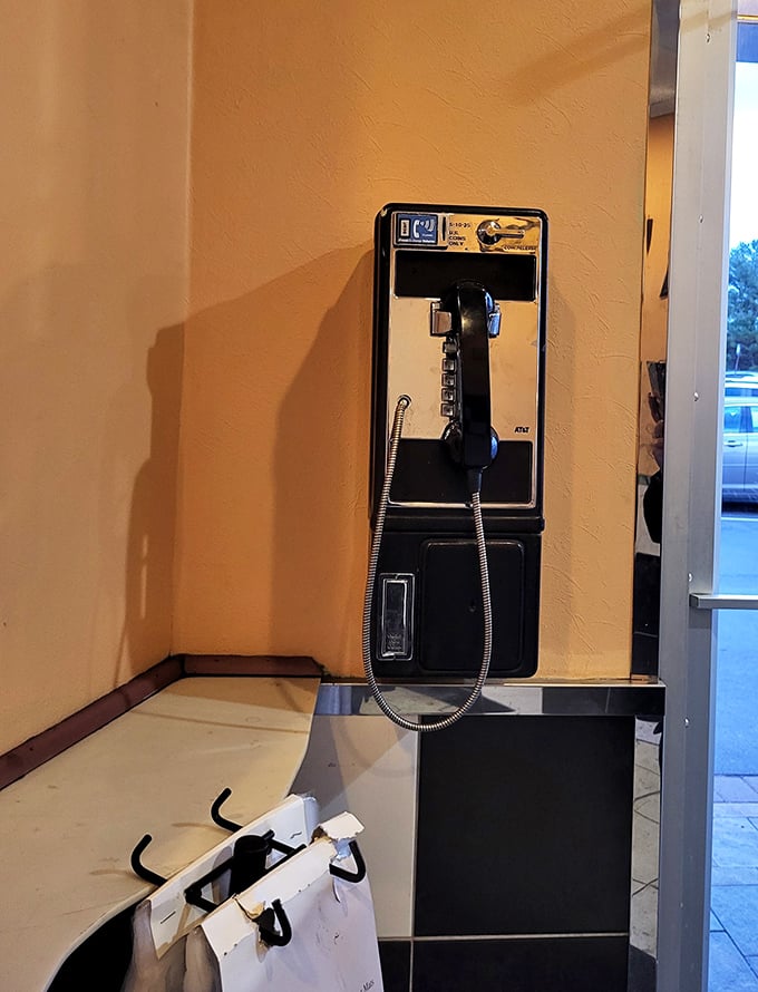 A payphone on the wall—perhaps the most honest indication you've found an authentic diner experience that refuses to completely surrender to modern times.