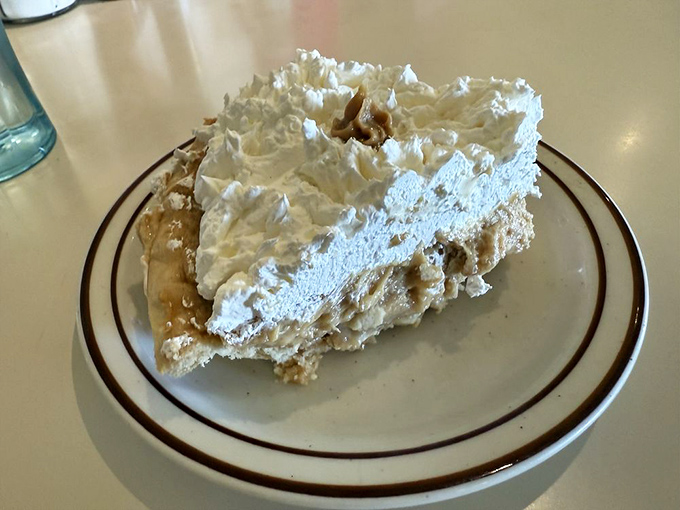 This isn't just pie—it's a cloud of whipped cream floating atop layers of peanut butter decadence that would make Elvis swivel his hips in approval.