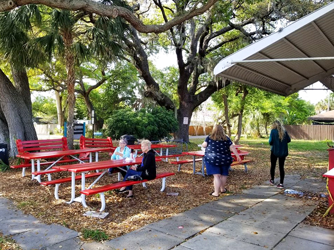 Picnic tables under ancient oaks—nature's dining room where strangers become friends, united by the universal language of great barbecue.