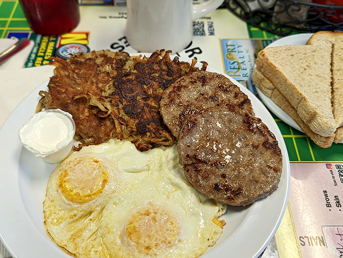 The breakfast trinity: perfectly cooked eggs, golden potato pancakes, and a sausage patty that means business. Simple food done extraordinarily well.