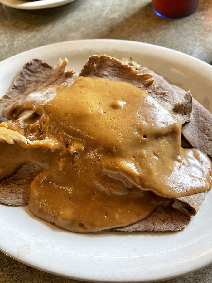 Roast beef draped in gravy like it's wearing a velvet robe. This isn't just dinner—it's a brown gravy spa treatment.