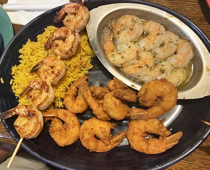 The shrimp lover's platter that makes decisions easy—why choose one preparation when you can have them all? Yellow rice never had better company.
