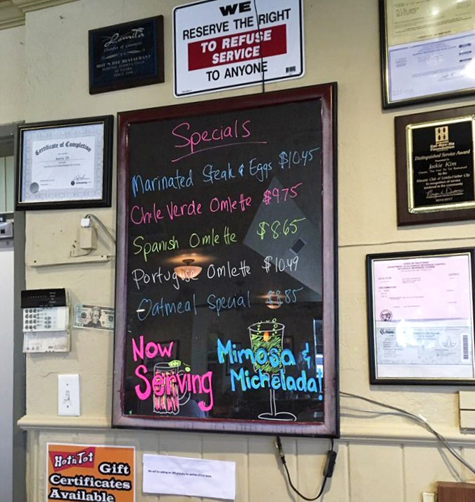 The specials board—a colorful canvas of culinary possibilities. Mimosas and micheladas suggest they understand weekend priorities.
