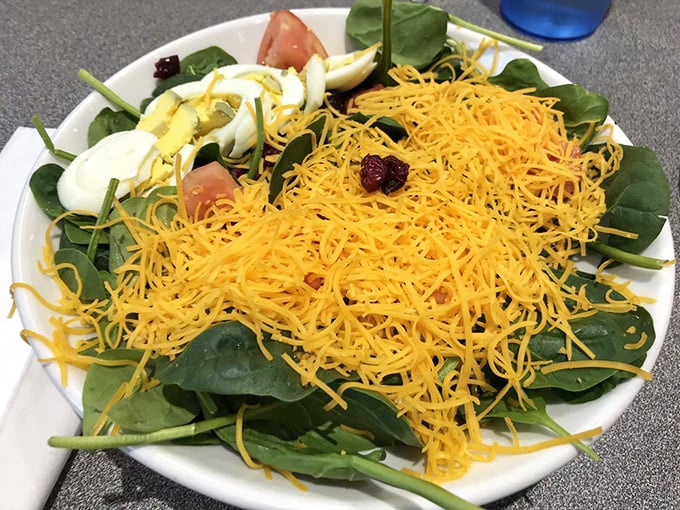 Even the salads get the Cincinnati treatment—fresh spinach playing host to that famous shredded cheddar crown.